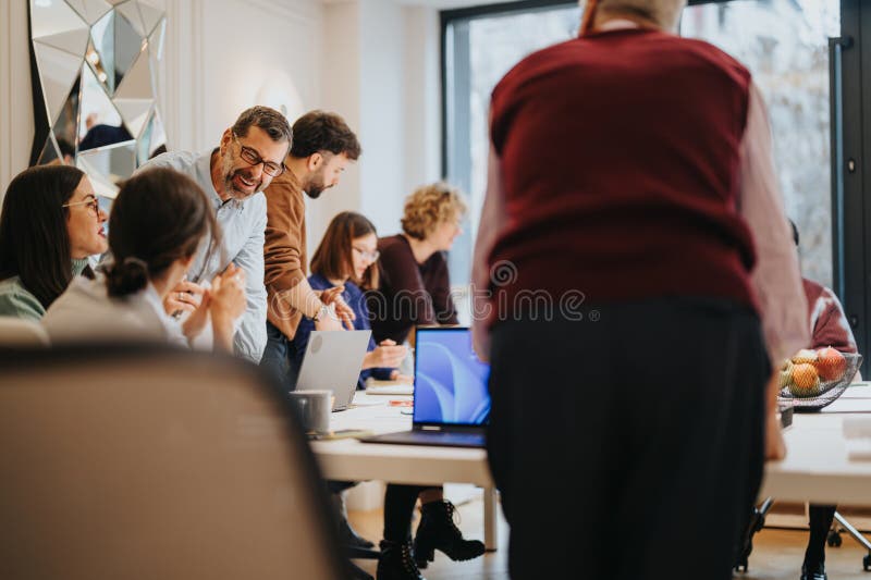 A Team of Employees Collaborates in a Vibrant Office Setting, Sharing a ...