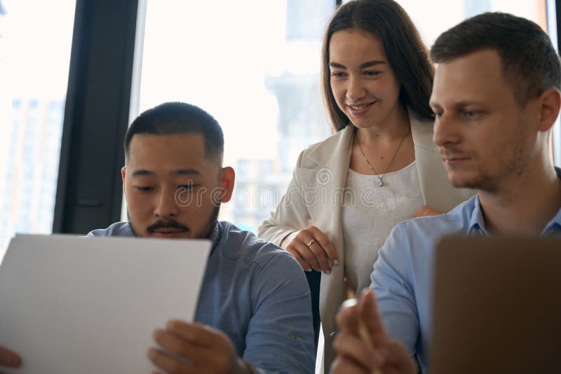 Team of Employees Discussing while Looking at Document in Office Stock ...
