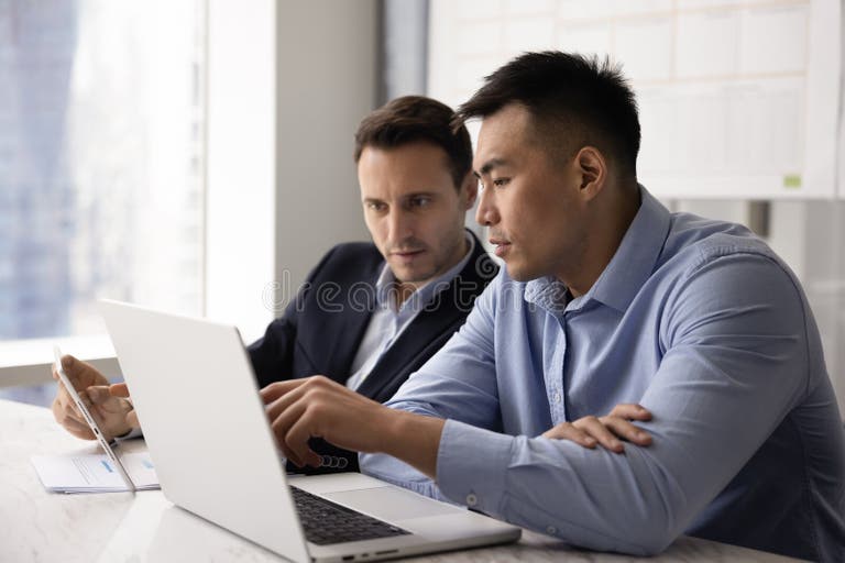 Team Engaged in Joint Task Completion Using Tablet and Laptop Stock ...