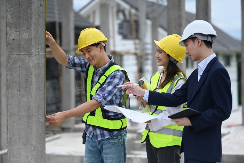 Team of Engineer and Architects in Safety Hard Hats Discussing about ...