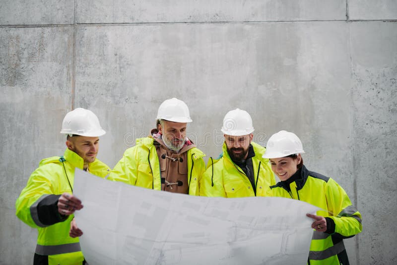 Engineers with Blueprints Discussing at Desk. Teams on Construction ...