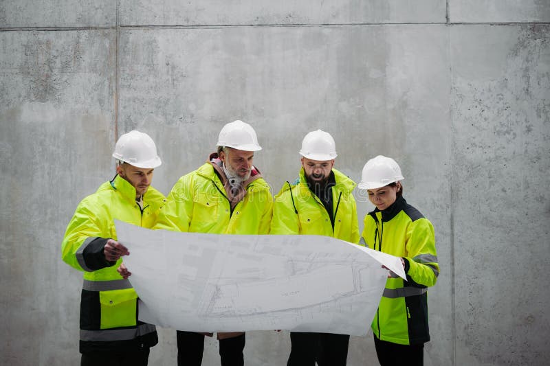 Engineers with Blueprints Discussing at Desk. Teams on Construction ...