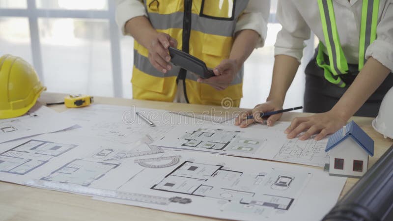 Team of Engineers Working Together on Blueprint Plan at Construction ...