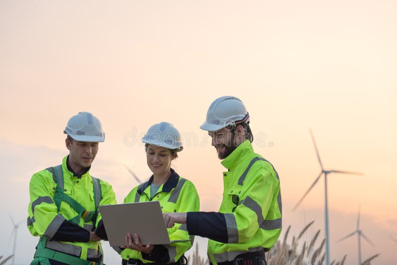 Team of Engineers Working and Using a Computer Laptop on Site in Wind ...