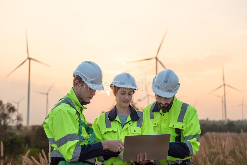 Team of Engineers Working and Using a Computer Laptop on Site in Wind ...