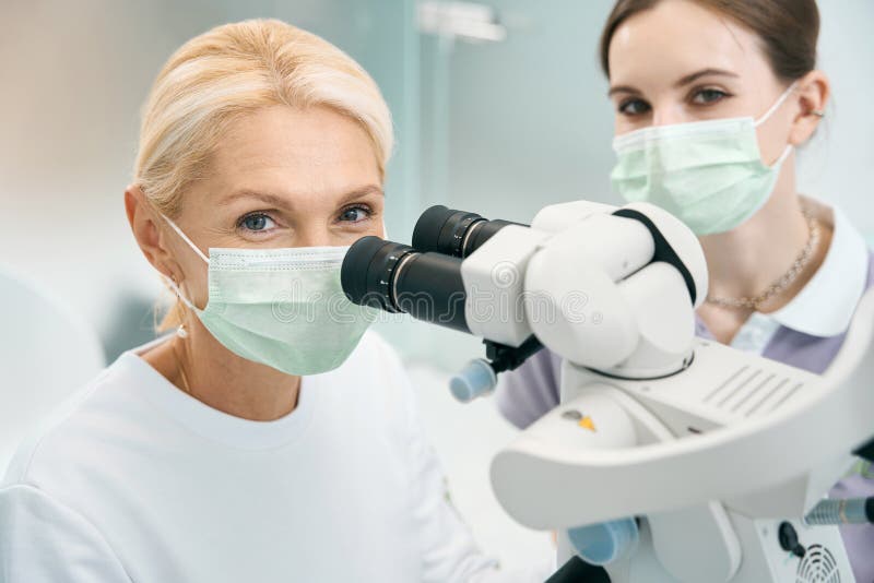 Team of Experienced Doctors Examine Under a Microscope Stock Image ...