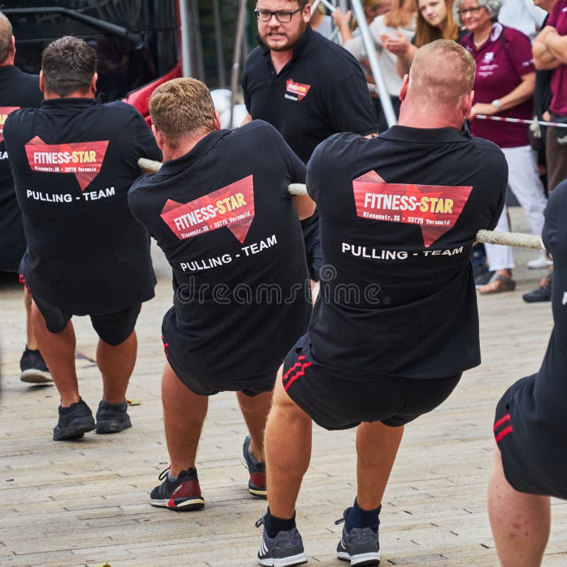 Championship in Bus Pulling on a Thick Rope with a Team of Three Men ...