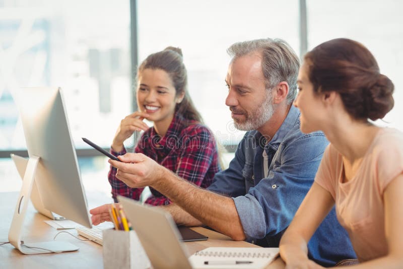 Team of Graphic Designers Discussing Over Computer at Desk Stock Image ...