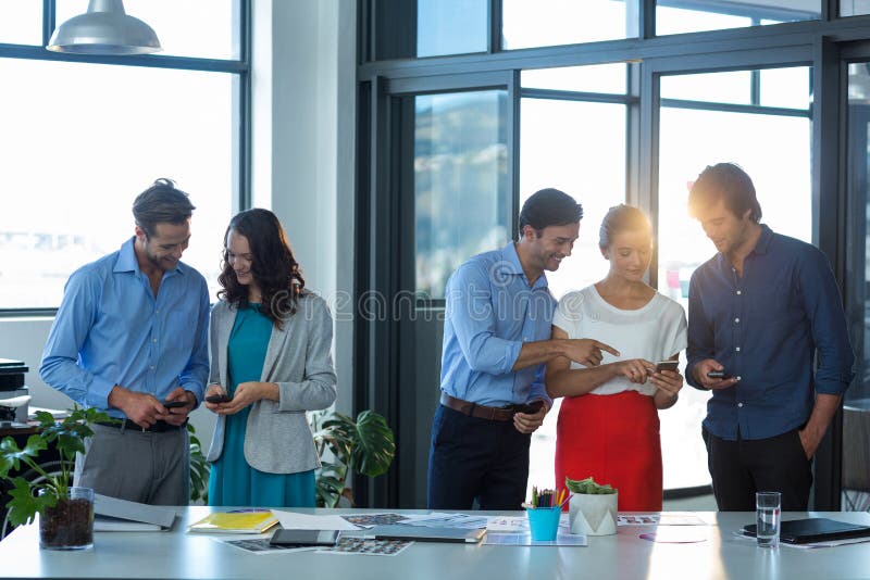 Team of Graphic Designers Using Mobile Phone Stock Photo - Image of ...