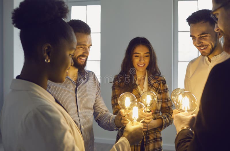 Multiracial Businesspeople Holding Glowing Light Bulb Joining Lamp ...