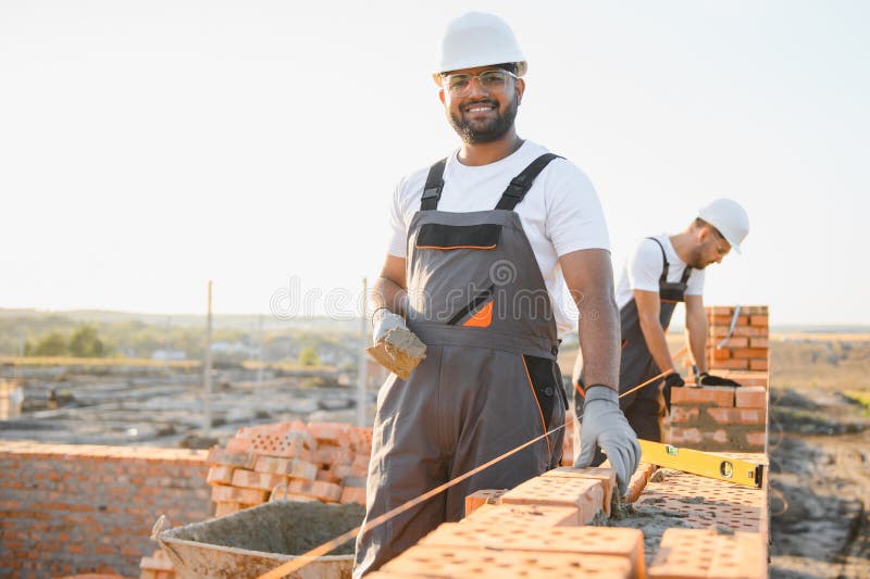 A Team of Indian Construction Workers in Overalls and Hard Hats are ...