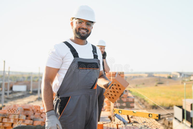 A Team of Indian Construction Workers in Overalls and Hard Hats are ...
