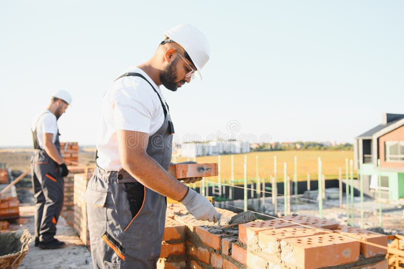 A Team of Indian Construction Workers in Overalls and Hard Hats are ...