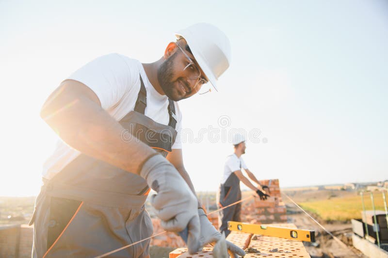 A Team of Indian Construction Workers in Overalls and Hard Hats are ...