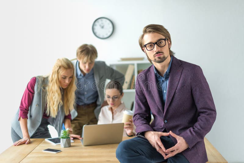 Team Leader Sitting on Table Stock Photo - Image of indoors, male ...