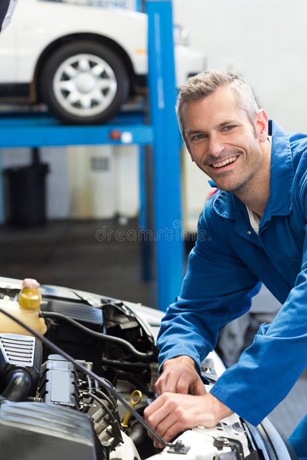 Mid Adult Man in Coveralls Leaning Over Open Hood Checking Engine at ...