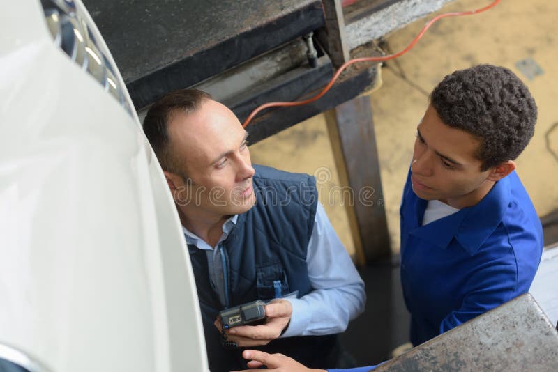 Team Mechanics Working Together in Workshop Stock Image - Image of ...