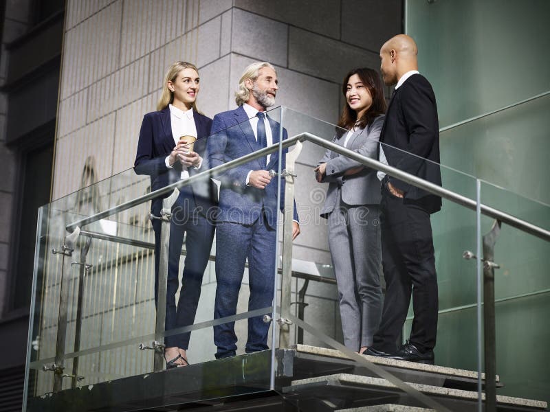 Team of Multiethnic Businesspeople Standing Talking Chatting Discussing ... Team of Multiethnic Businesspeople Standing Talking Chatting Discussing ...