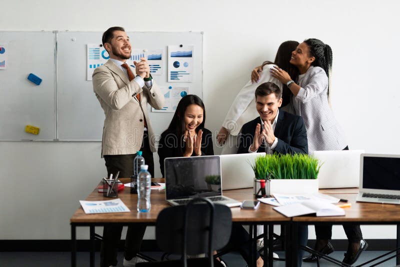 A Team of Office Workers while Rejoicing while Looking at a Laptop ...