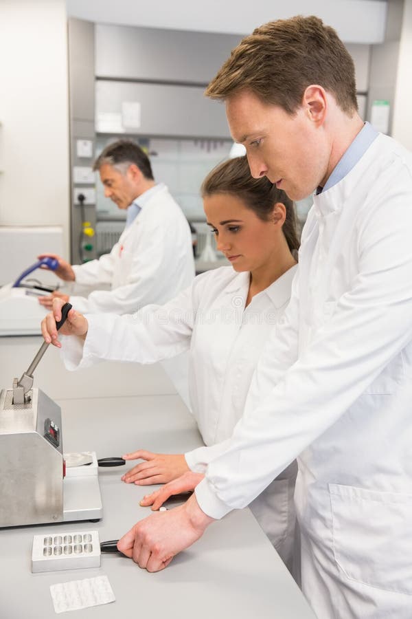 Team of Pharmacists Using Press To Make Pills Stock Image - Image of ...