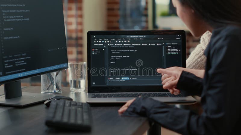 Team of Programmers Talking about Algorithm Running on Laptop Screen Pointing at Source Code ...