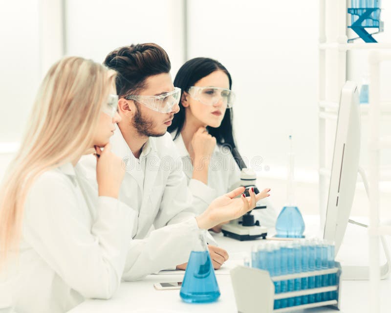 Team of Scientists Discussing Something at the Desk Stock Image - Image ...