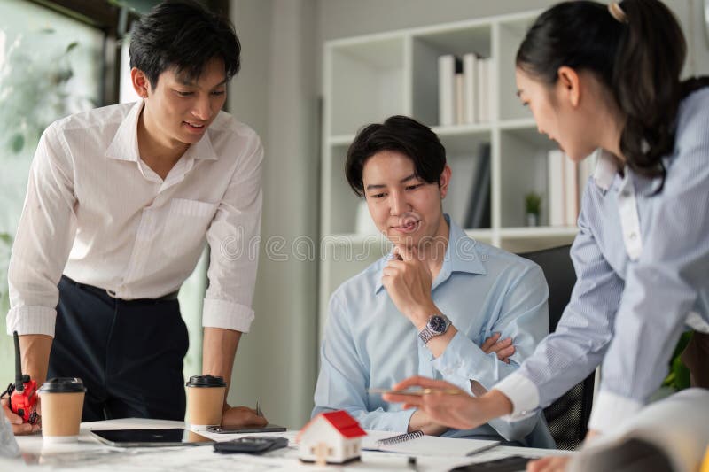 Design Presentation and Collaboration. a Professional Team Discussing a Model House Design with ...
