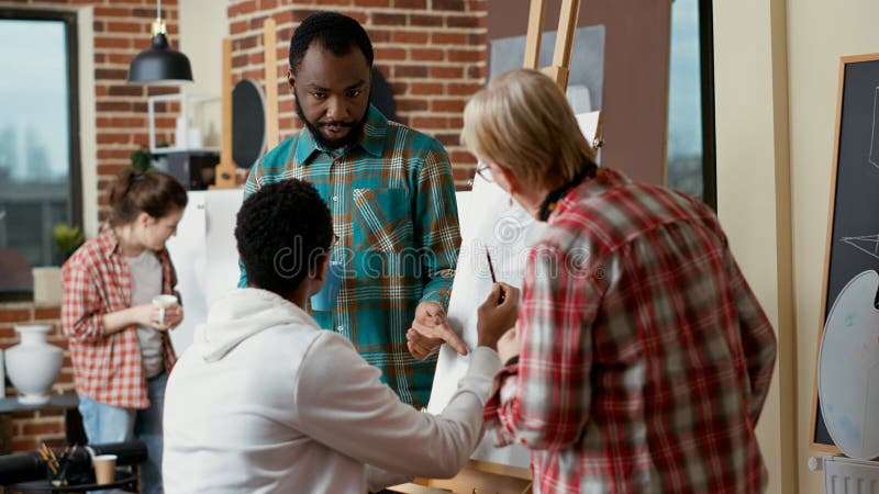 Team of Students Discussing Sketch Drawing with Old Artist Stock Photo ...