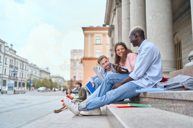 Team of Students Using a Laptop Sitting on the Steps. Stock Photo ...
