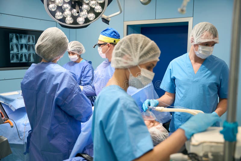 Team of Surgeons Performs an Operation, a Patient Under Anesthesia ...