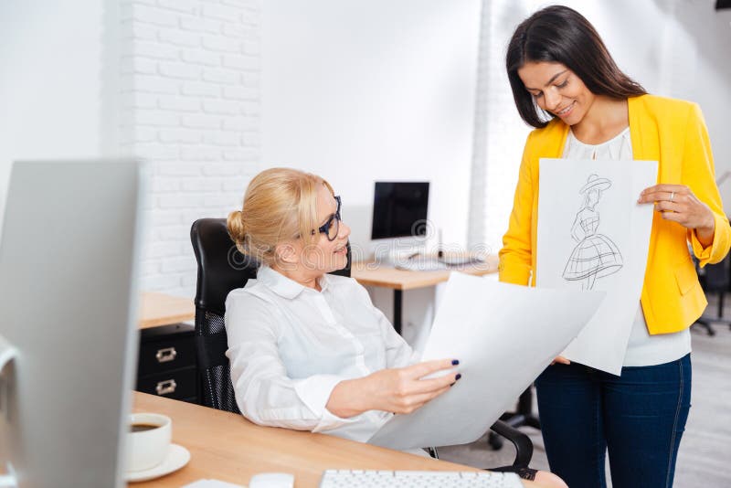 Team of Two Female Architects Discussing Sketches at the Office Stock ...