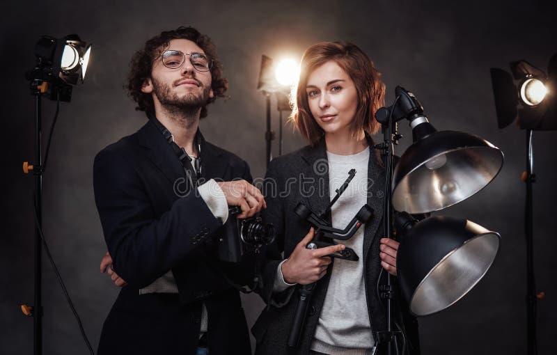 The Team of Two Photographers Holds a Digital Camera and Lighting ...