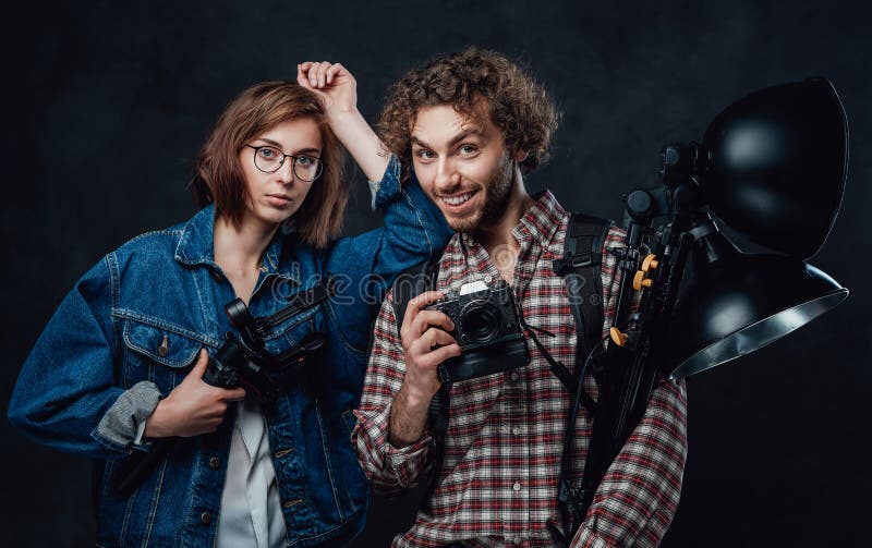 The Team of Two Young Photographers Holds a Digital Camera and Lighting ...