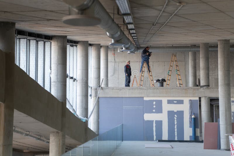 A Team of Workers Collaborates To Install a Modern Ventilation System ...