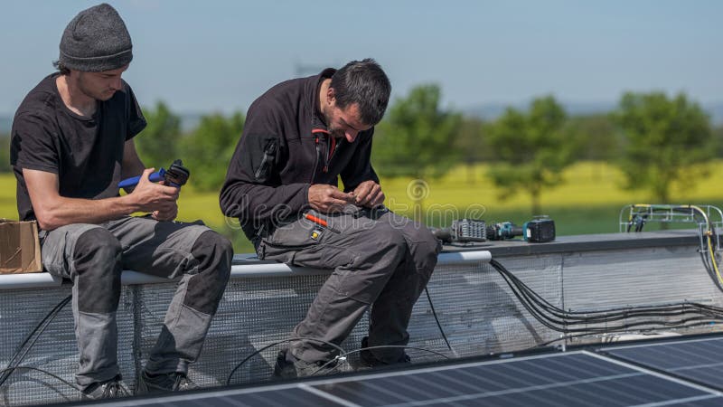 Team of Workers Preparing Electrical Connection Cables for Solar Panels ...