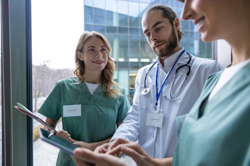 Team of Young Doctors Discussing Something and Looking Interested and ...