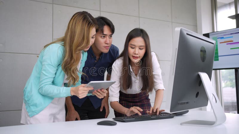A Team of Young Multinational Business People Using Computer and ...