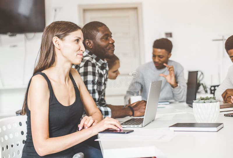 A Team of Young Office Workers, Businessmen with Laptop Working at the Table, Communicating ...