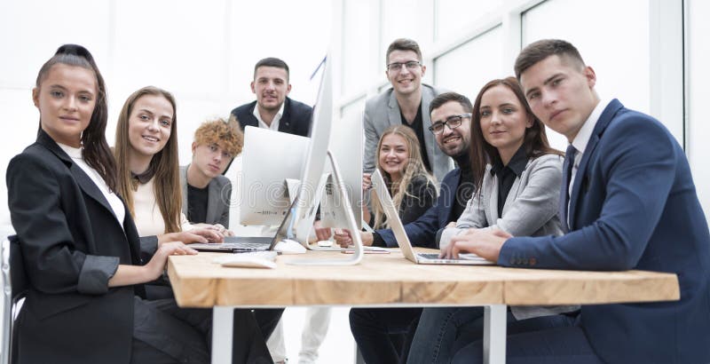 Team of Young Professionals Sitting at an Office Desk Stock Photo ...