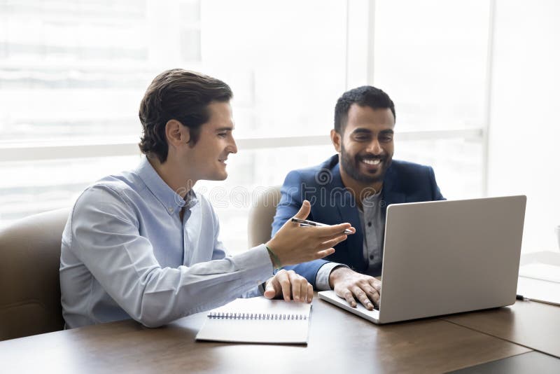 Teammates Working on Joint Project Seated at Desk Using Laptop Stock ...