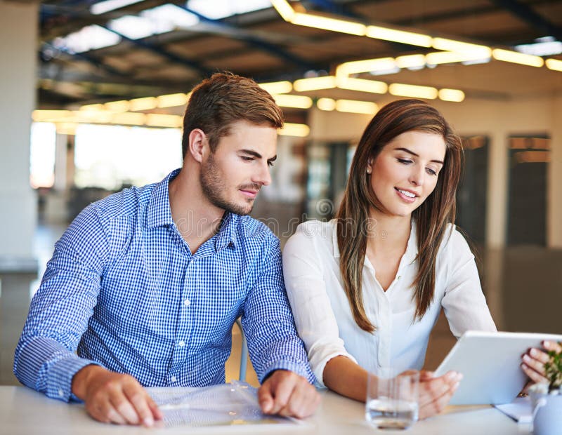 Teamwork in Action. Two Colleagues Working Together on a Digital Tablet in an Office. Stock ...