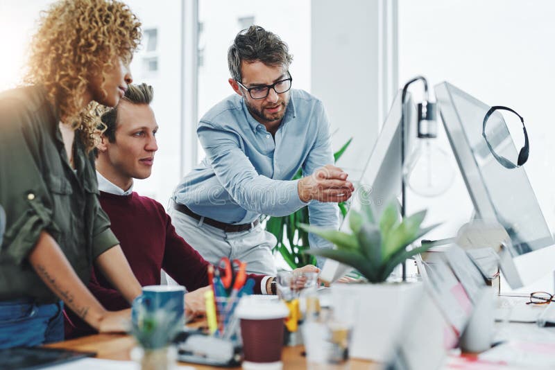 Teamwork is always the Answer. a Group of Colleagues Using a Computer ...