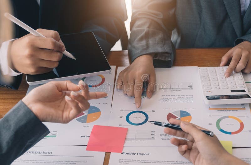 Teamwork with Business People Analysis Cost Graph on Desk at Meeting ...