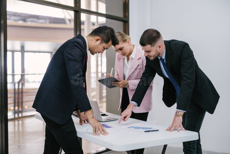 Teamwork with Business People Analysis Cost Graph on Desk at Meeting ...