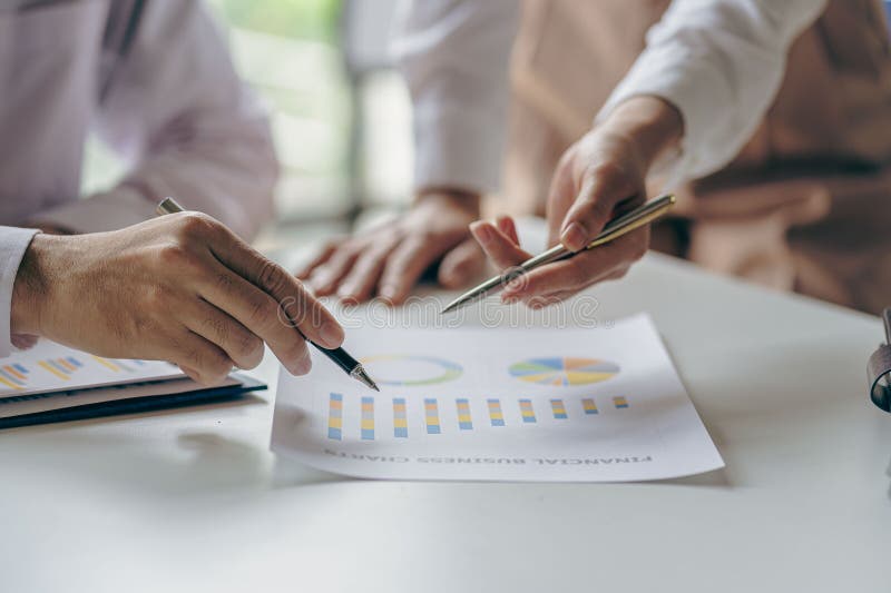 Teamwork with Business People Analyzing Cost Graphs on a Table at a ...