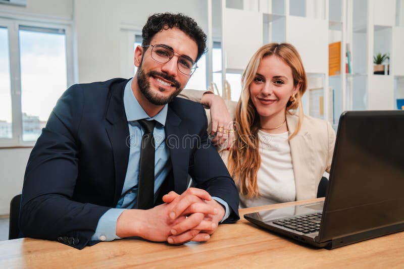Teamwork of Businesspeople Sitting on Desk and Looking at Camera. Two ...