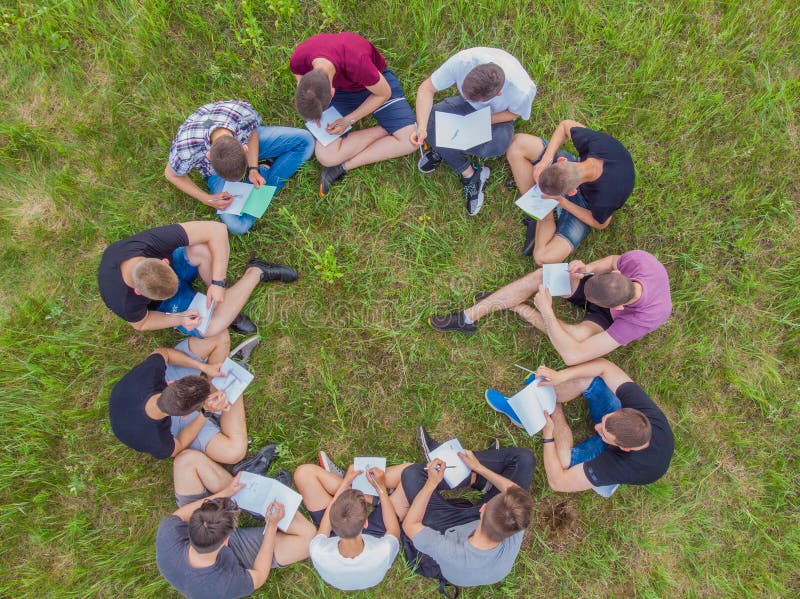 Teamwork Concept. a Group of High School Students Sit on the Grass in a ...