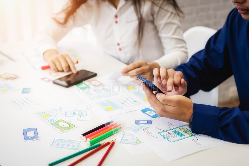 Teamwork of Designers Planning Application for Mobile Phone. User ...