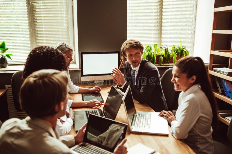 Teamwork of Diverse Group Sitting at Negotiation Table with Computers ...