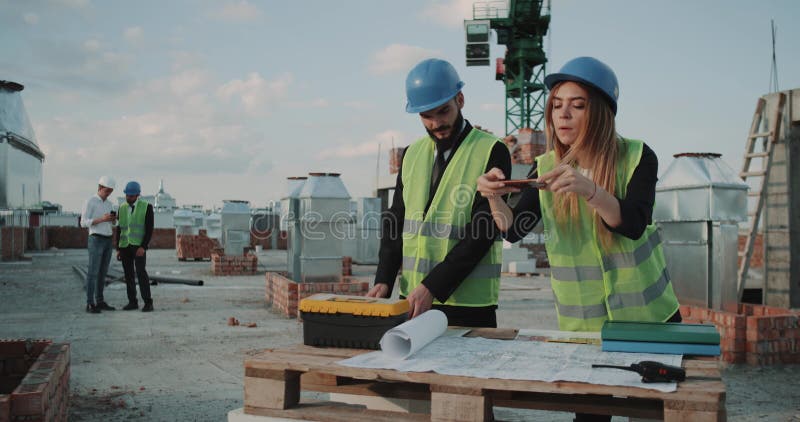 Teamwork of Engineers Analyzing the Map of Construction Site Using a ...